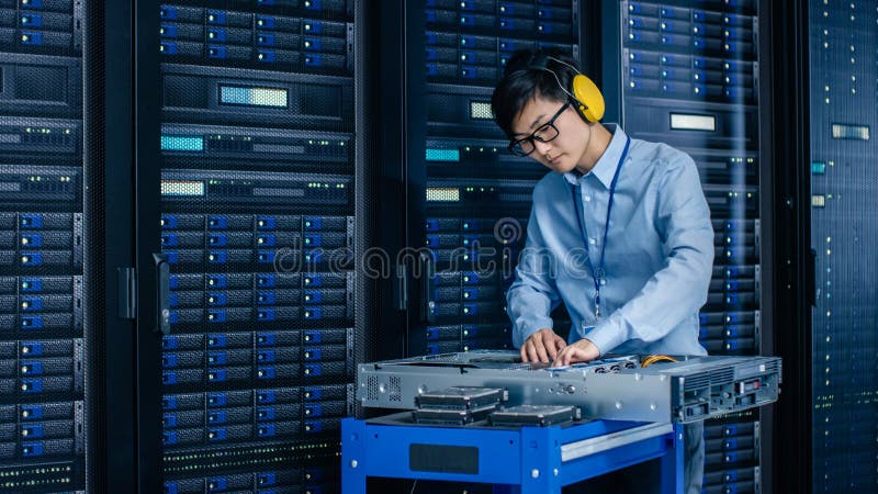 In Data Center: it Engineer Wearing Protective Muffs Installs New Hardware for Server Rack ...