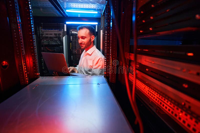 Data Center System Administrator Checking Server Settings with Laptop ...