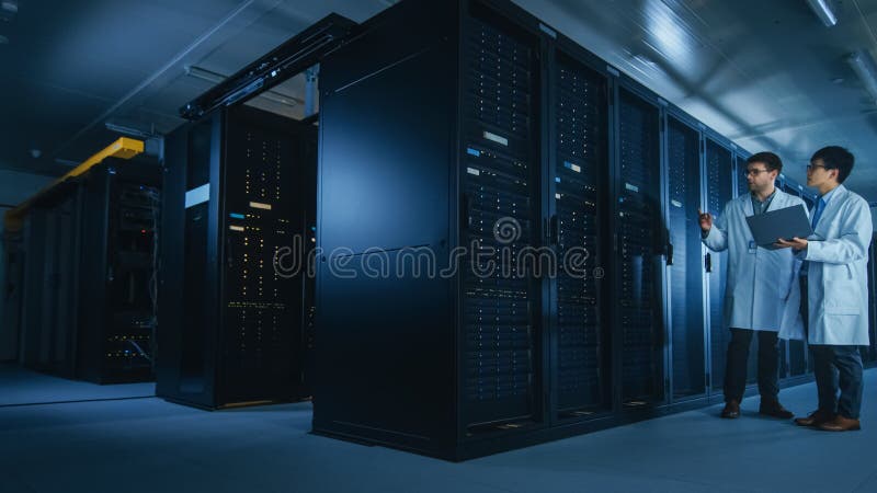In the Data Center: Two it Specialists Wearing White Lab Coats, Have ...