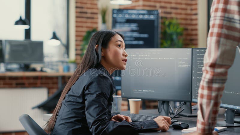 Database Developer Pointing Pencil At Computer Screen With Software Compiling Code Explaining