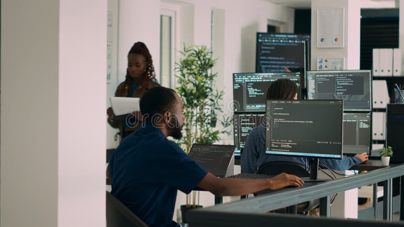 Programer Working at Desk with Multiple Computer Screens and Laptop with Green Screen Chroma Key ...