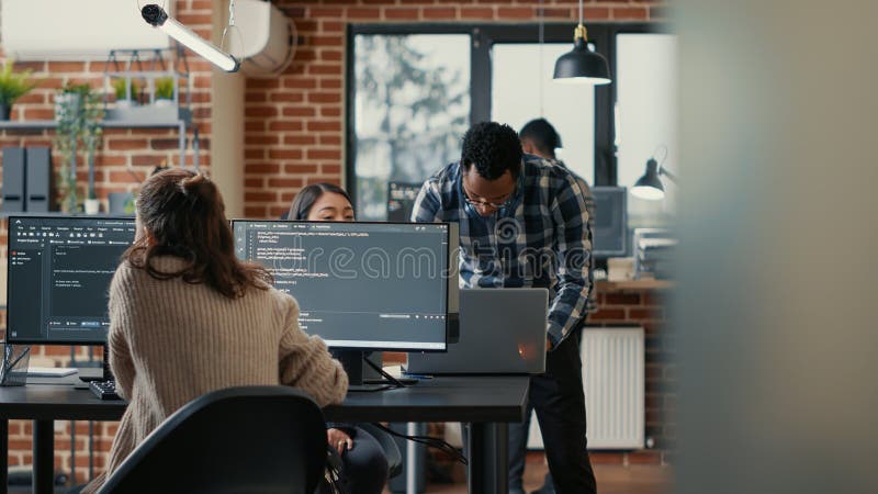 Programer Working at Desk with Multiple Computer Screens and Laptop with Green Screen Chroma Key ...