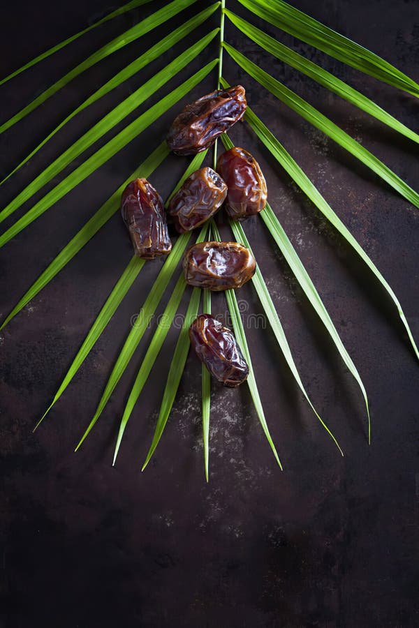 Dates and Leaves on Black Background, Top View. Stock Image - Image of ...