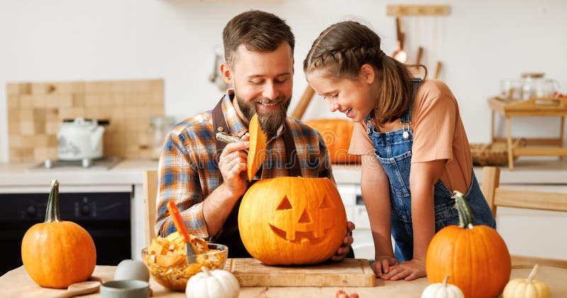 Daughter And Dad Making Jack O Lantern Together At Home Carving