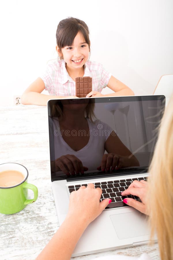 Daughter eating chocolate stock photo. Image of laptop - 58890742