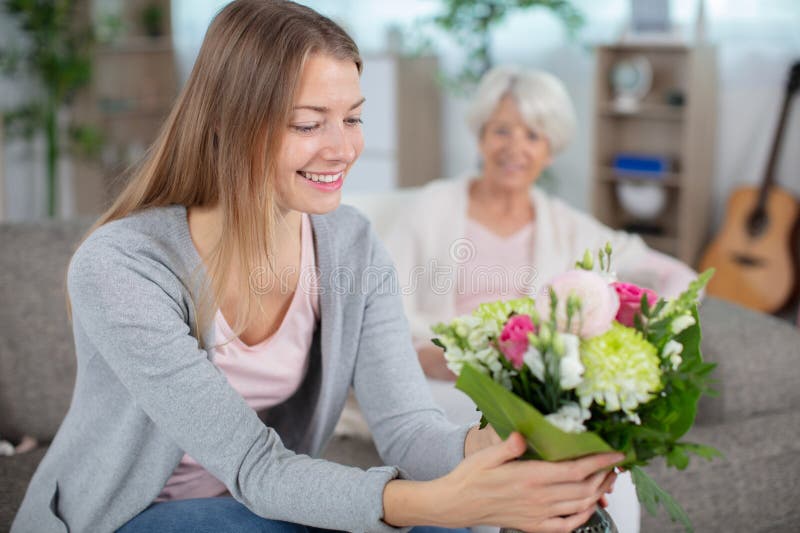 Daughter Giving Flowers To Mom Stock Image - Image of mature, home ...