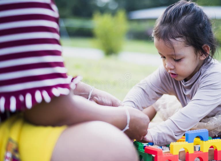Daughter and Mother Playing with Legos on the Front Yard. Concept of ...