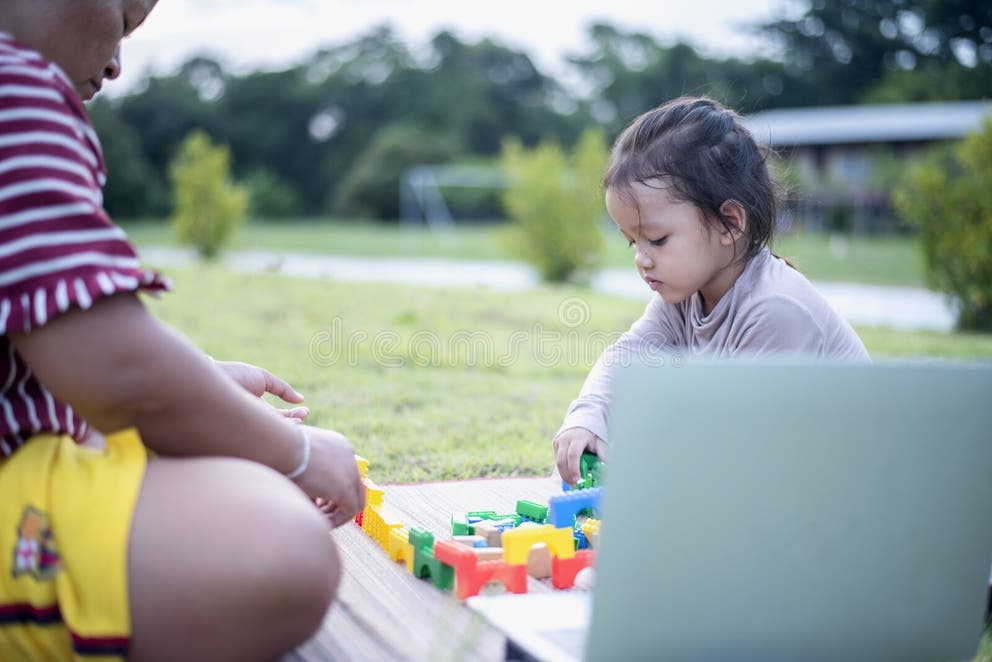 Daughter and Mother Playing with Legos on the Front Yard. Concept of ...