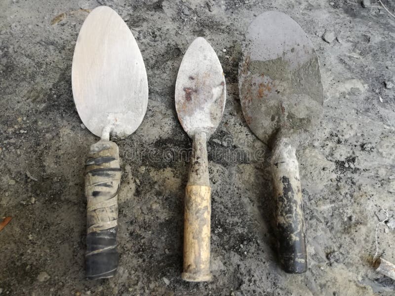Three Spoons of Cement with Different Shape and Sizes , on a Cement ...