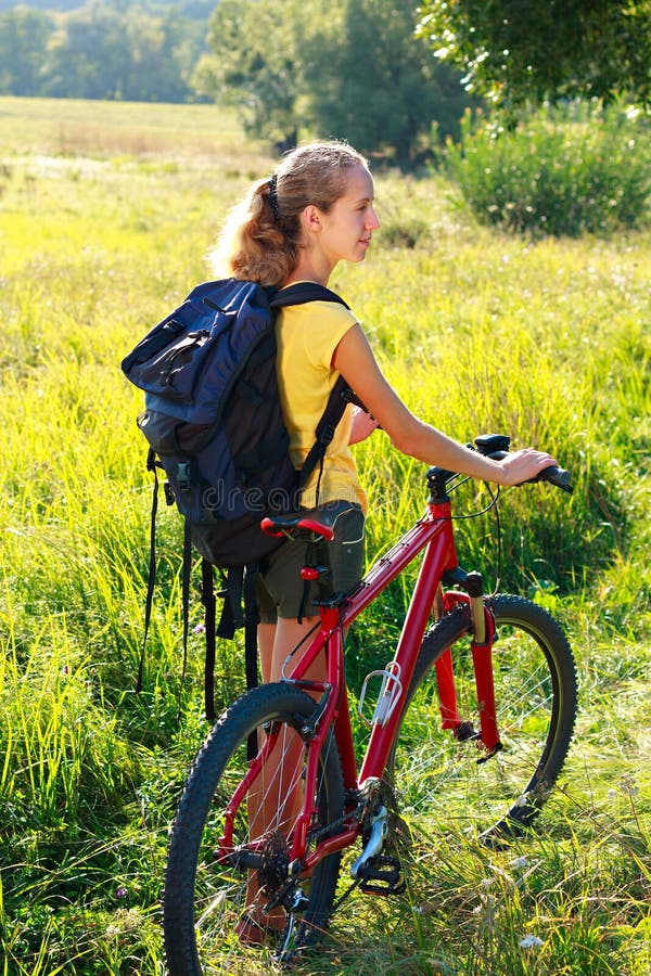 De Fietser Van De Vrouw Met Fiets En Rugzak Stock Foto - Image of licht ...