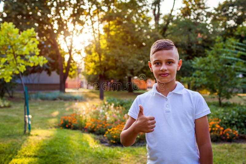 De Gelukkige Tienerjongen Die Duim Tonen Ondertekent Omhoog in De ... De Gelukkige Tienerjongen Die Duim Tonen Ondertekent Omhoog in De ...