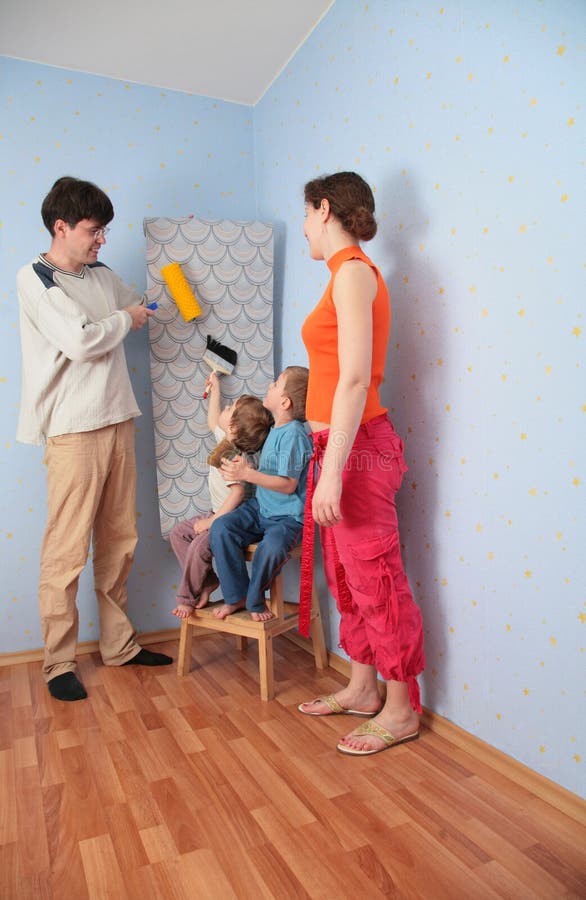De Kinderen Helpen Ouders Om Behang Te Lijmen Stock Foto - Image of ...