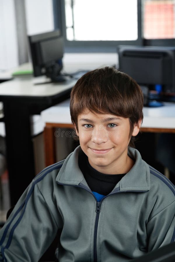 Middelbare Schoolstudent Smiling while Sitting Bij Bureau Stock Foto ... Middelbare Schoolstudent Smiling while Sitting Bij Bureau Stock Foto ...