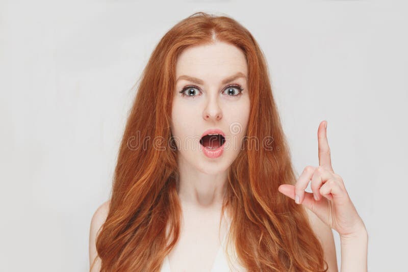 De Mooie Roodharige Verraste Vrouw Neemt De Vinger Op Op Witte