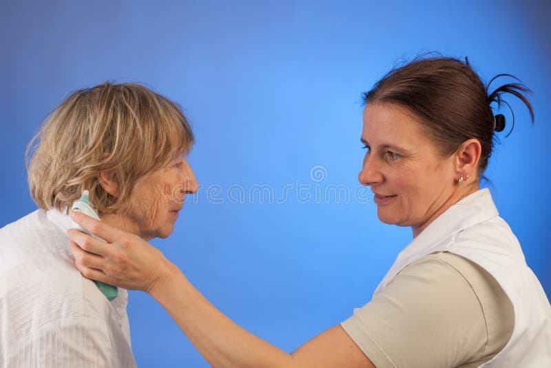 De Verpleegster Helpt Een Bejaarde Met Zich Het Kleden Stock Foto