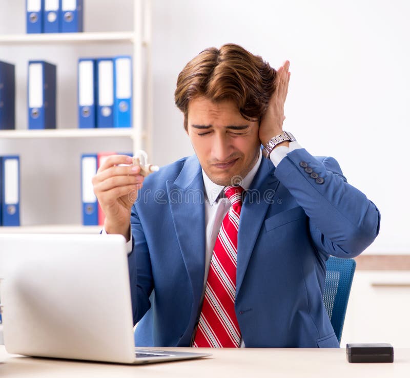 Deaf Employee Using Hearing Aid in Office Stock Photo - Image of ...