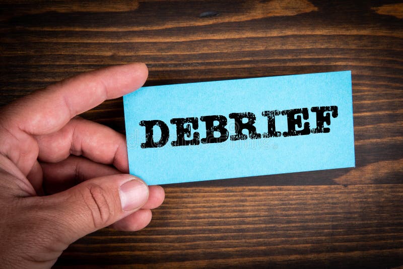DEBRIEF Concept. Blue Paper Sheet with Text in Man& X27;s Hands, Wooden ...