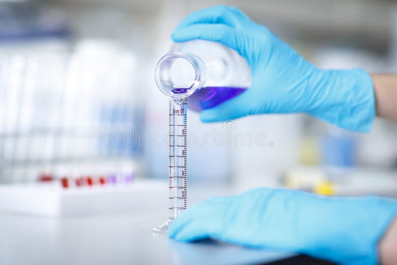 Decanting a Violet Liquid into a Graduated Cylinder Stock Photo - Image ...