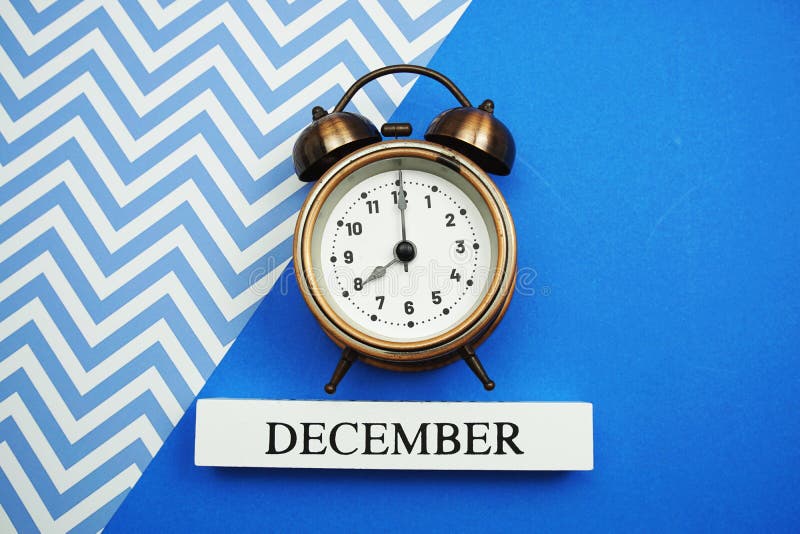 December and Alarm Clock on Blue Background Stock Photo - Image of ...