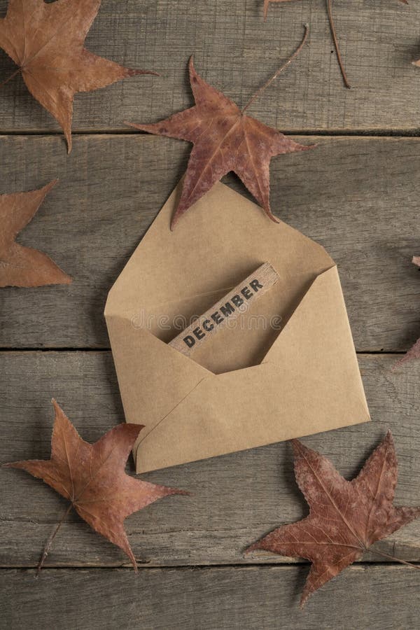 December Template with Envelope and Autumn Leaves on Table Stock Photo ...