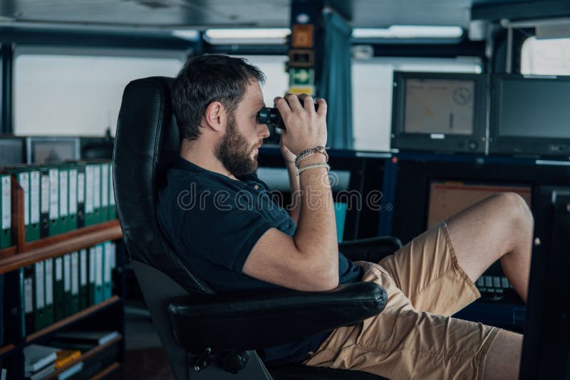 Deck Navigation Officer on the Navigation Bridge. he Looks through ...
