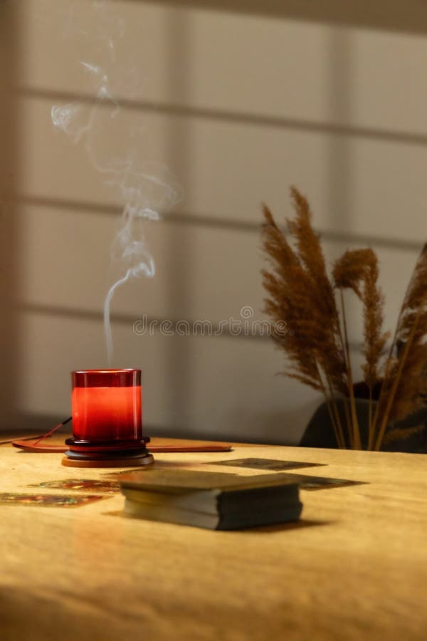 A Deck of Tarot Cards and a Red Candle on the Background of a Wall with ...