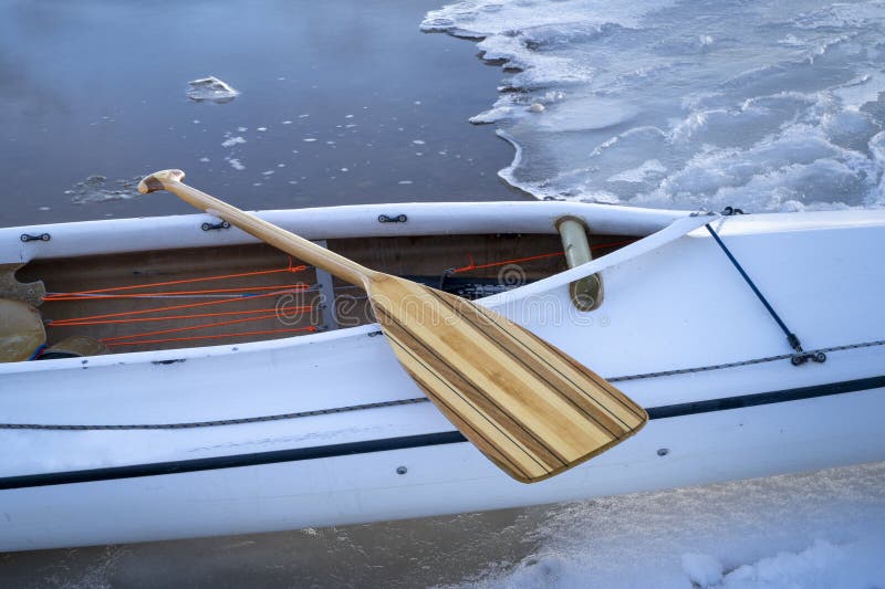 Decked Expedition Canoe with a Wooden Paddle on an Icy Shore Stock ...
