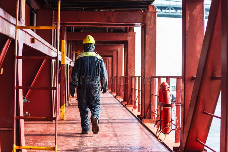 A Deckhand, Seen from Behind, Walks Across the Deck of a Container Ship ...