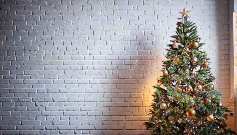 Decorated Christmas Tree Over White Brick Wall with Lights Stock ...
