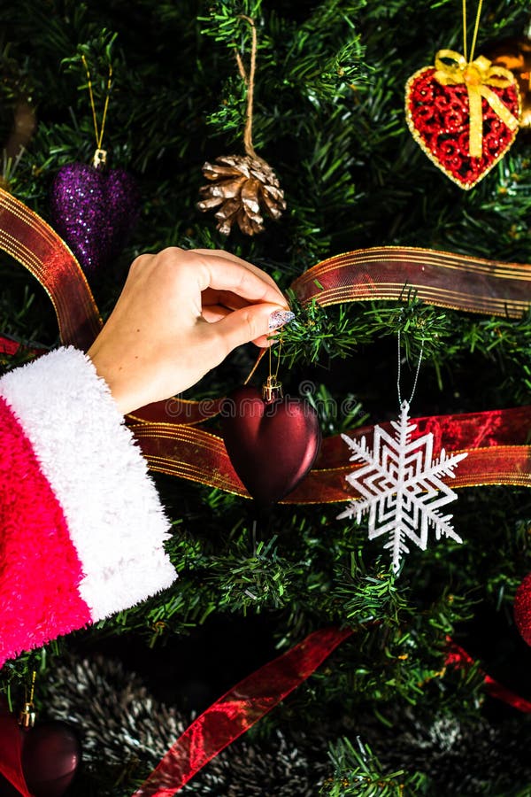 Decorating Christmas Tree, Hand Putting Christmas Decorations on Fir ...