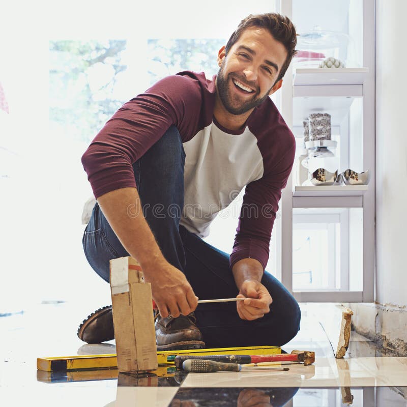 Decorating One Tile at a Time. Portrait of a Smiling Man Laying Floor ...
