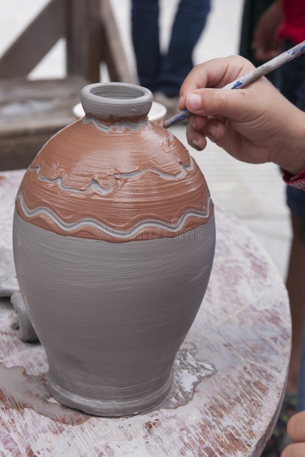 Decorating a wet clay pot stock photo. Image of craft - 77050576