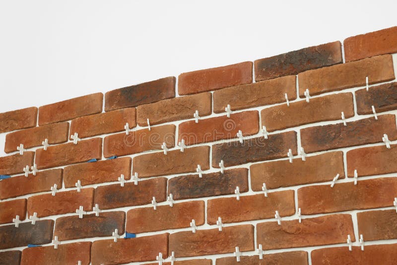 Decorative Bricks with Tile Leveling System on White Wall Stock Image ...