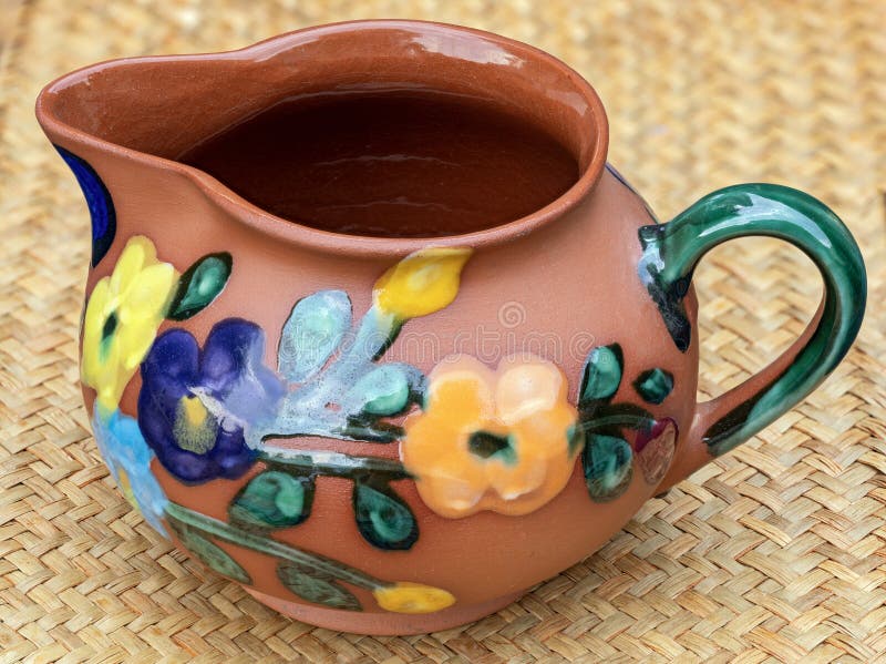 A Decorative Ceramic Pitcher on a Woven Placemat Stock Photo - Image of ...