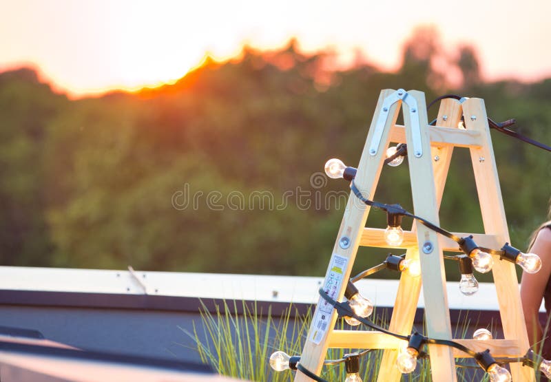 Photo of Decorative Ladder with Lights Against Sunset at Rooftop Stock ...