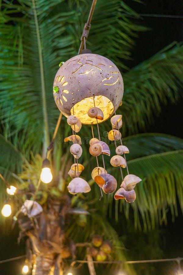 A Decorative Lamp and Shade with Snail Shells Dangling Below Lights Up ...