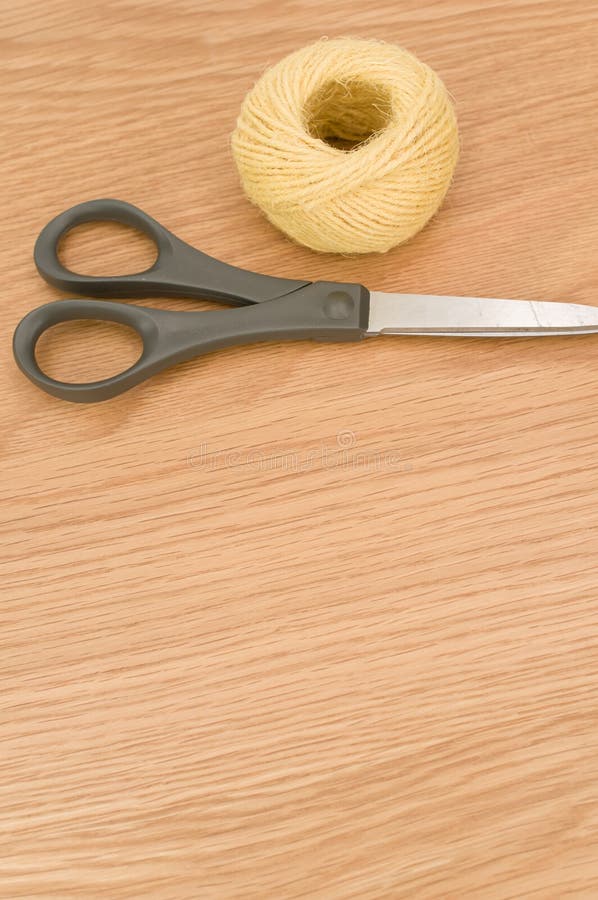 Decorative Rustic Yellow Yarn Ball and Scissors on a Wooden Tabletop ...