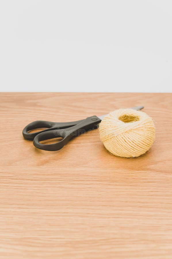Decorative Rustic Yellow Yarn Ball and Scissors on a Wooden Tabletop ...