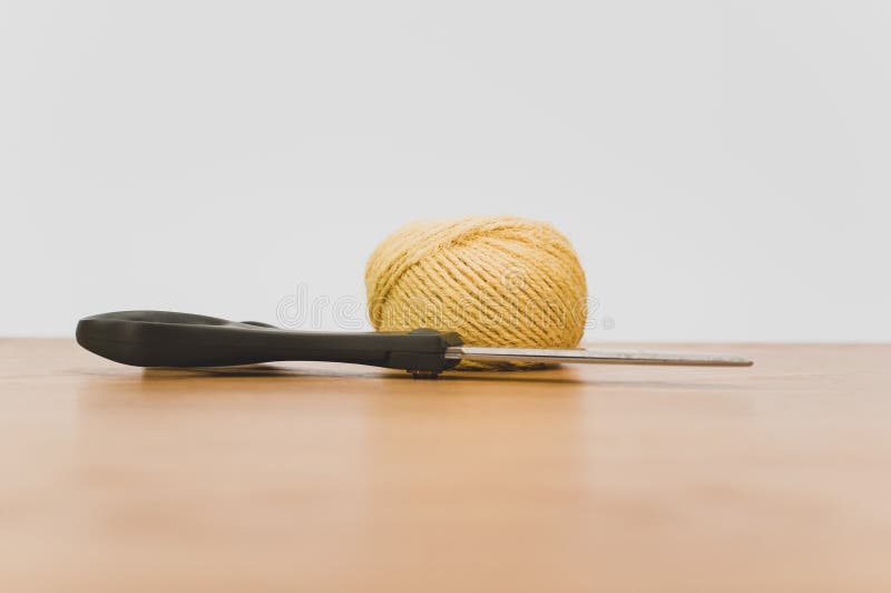Decorative Rustic Yellow Yarn Ball and Scissors on a Wooden Tabletop ...