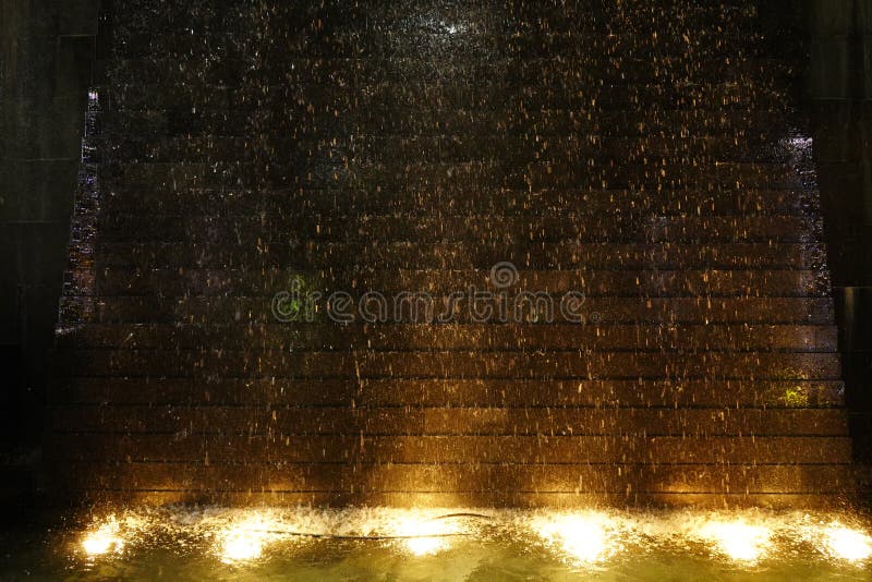 Decorative Waterfall with Yellow Light Lighting Up from Under the Water ...
