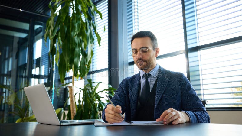 Dedicated Executive Taking Notes while Organizing Plans for Corporate ...