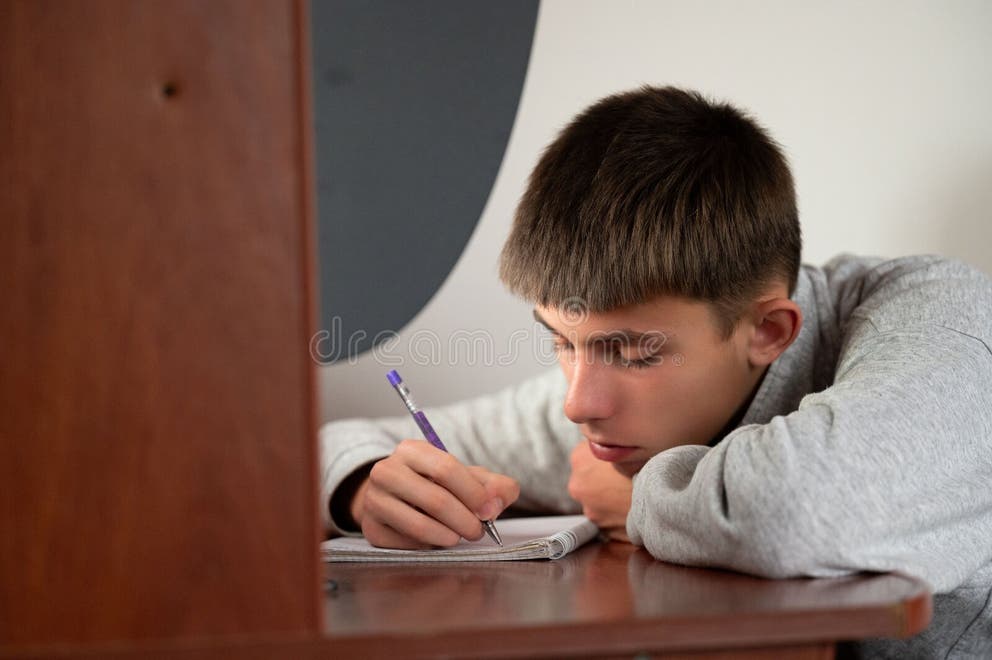 A Dedicated and Focused Student is Diligently Engaged in Taking Notes ...