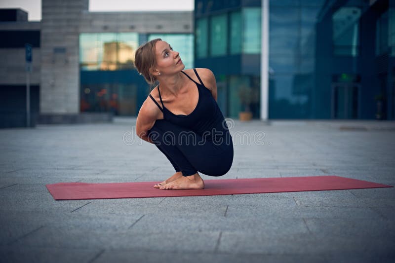 Yoga Practitioner Performs a Challenging Pose on a Mat in an Urban ...