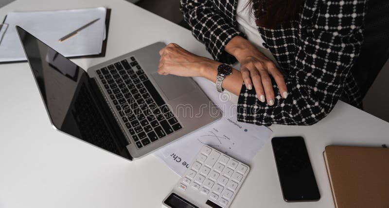 Office Worker Checking Time while Working Late at Night in a Modern ...