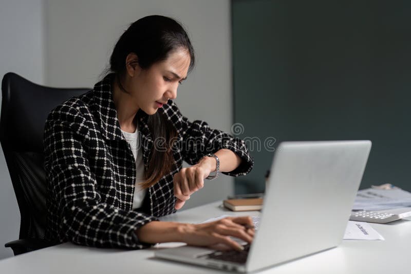Office Worker Checking Time while Working Late at Night in a Modern ...