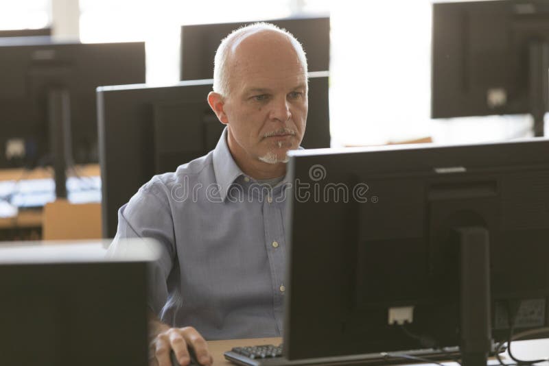Dedicated Senior Businessman Working at a Desktop Stock Photo - Image ...
