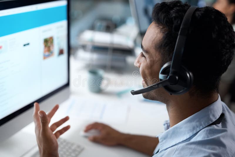 Dedicated Support at Your Service. a Young Man Using a Headset and ...