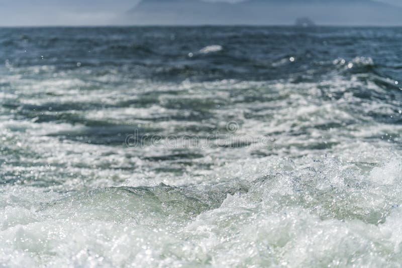 A Deep Blue Sea with Island in Distance with Medium Water Wave Ripple ...