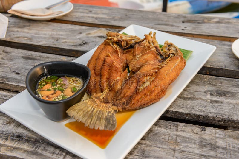 Deep Fried Snapper Topped with Sweet Fish Sauce on Wooden Table Stock ...