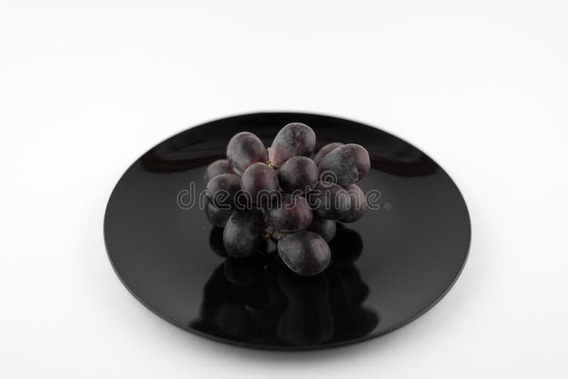 Deep Red Bunch of Grapes on Black Plate, Isolated on White Background ...